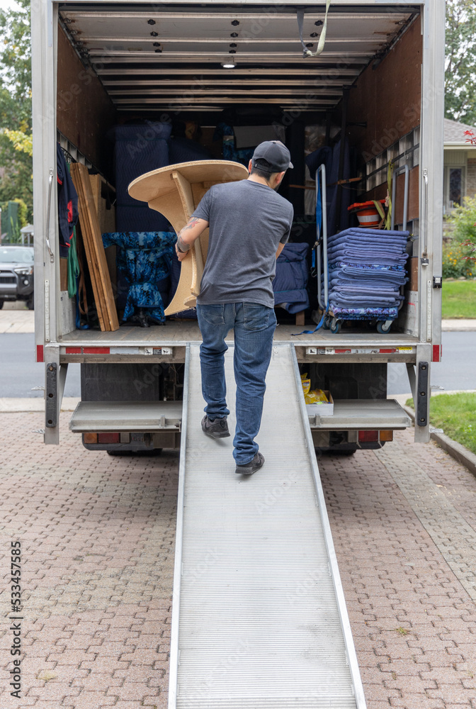 Professional mover carrying furniture Stock Photo | Adobe Stock