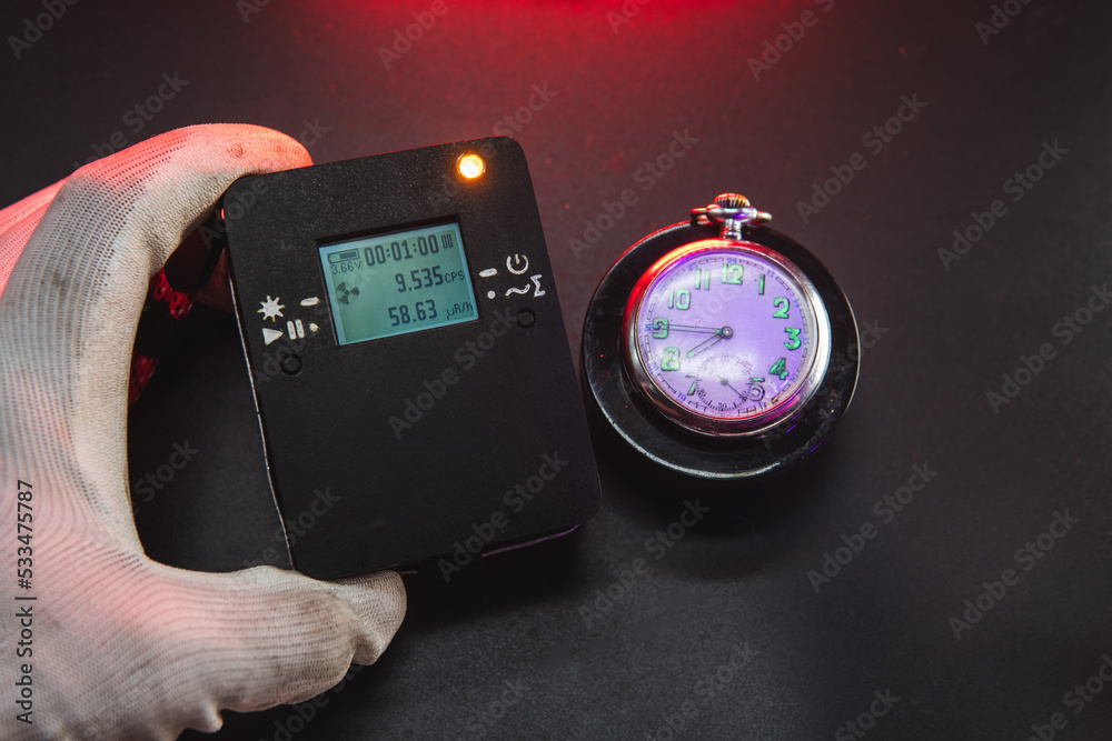 Foto de Man hand use dosimeter of radioactive radiation next to an old ...