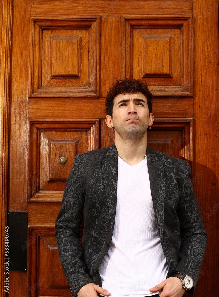 muchacho joven con saco negro en puerta de madera pensando Stock Photo ...