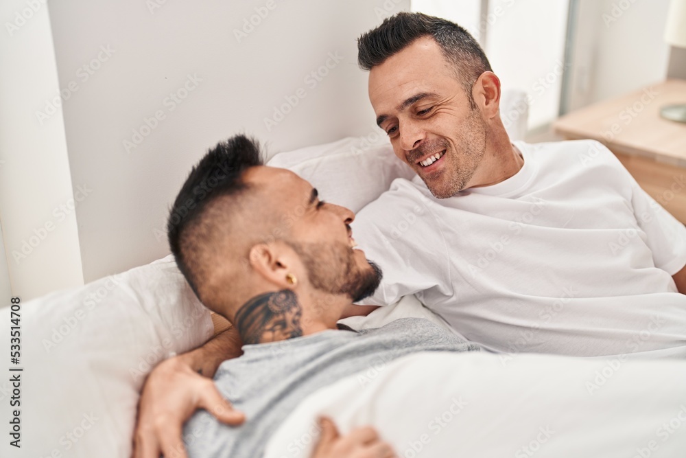 Two men couple lying on bed hugging each other at bedroom Stock Photo ...