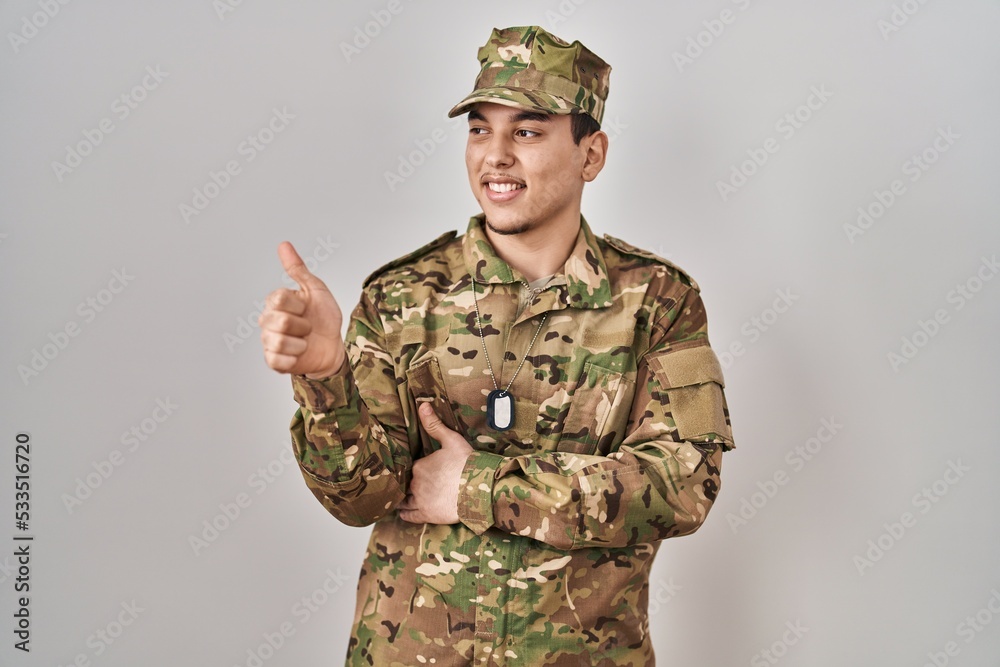 Young arab man wearing camouflage army uniform looking proud, smiling ...