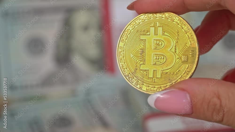 Gold coin of bitcoin on the background of one hundred dollar bills ...