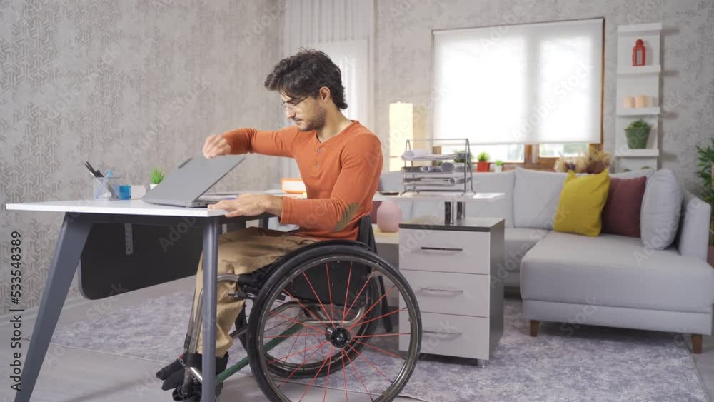 Disabled teenager in wheelchair working with laptop. Disabled teenager ...
