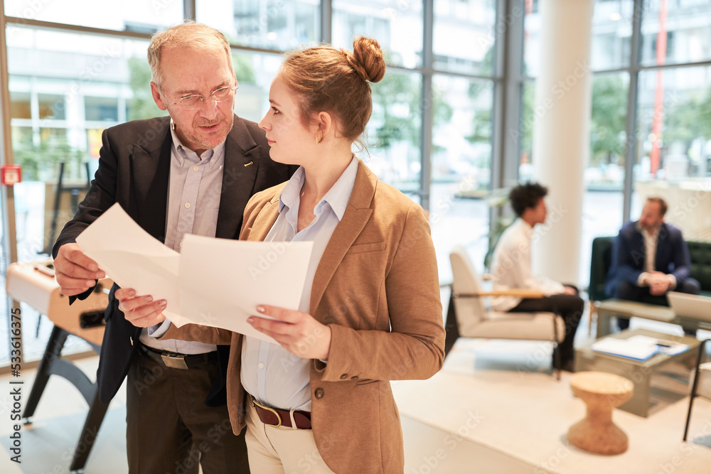 Manager and young colleague examine an annual report Stock Photo ...