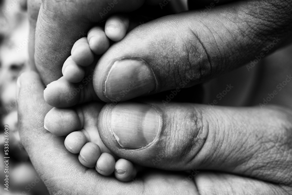 Mother is doing massage on her baby foot. Closeup baby feet in mother ...