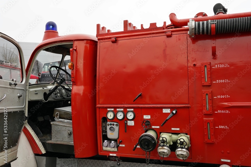 View on vintage red fire-brigade truck with open door of driver cabin ...