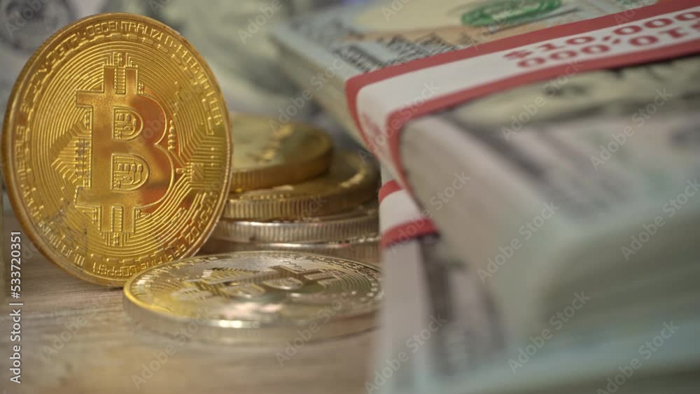 Gold coin of bitcoin on the background of one hundred dollar bills ...