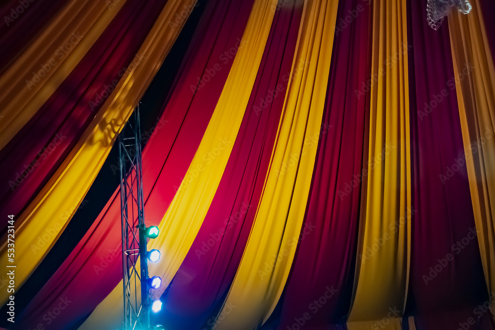 Ceiling decorated with heavy fabrics and light bulbs to show a circus ...