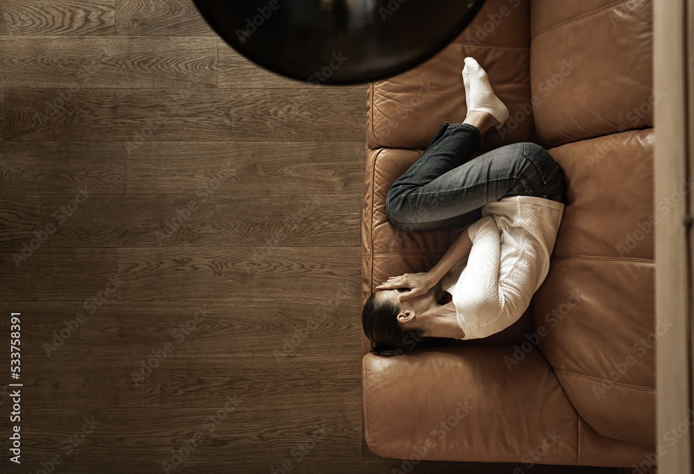 Sad frustrated depressed girl young woman curled up on couch at home ...