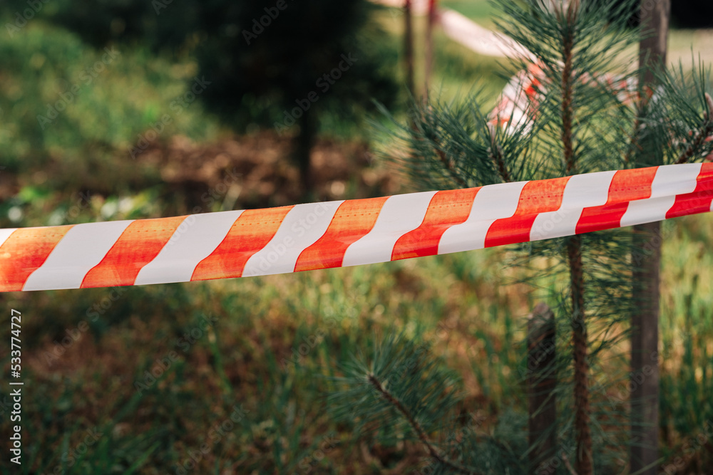 Red and white warning lines of barrier tape prohibit passage. Danger ...
