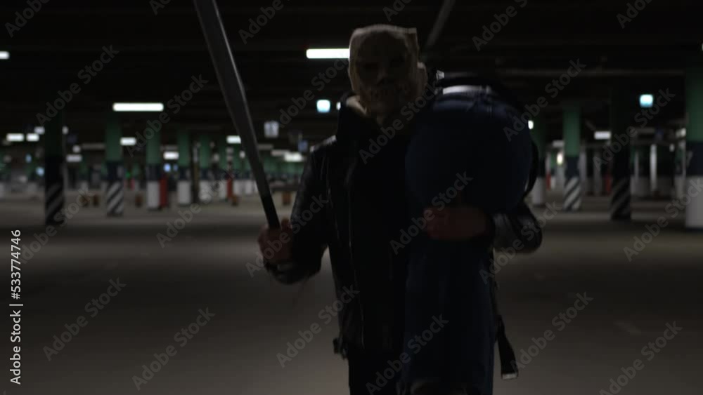 Male killer in scary scarecrow mask with baseball bat in his hands ...