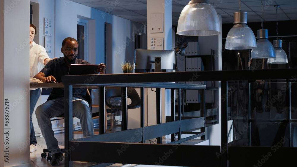 Diverse coworkers leaving office job late at night, working aster hours ...