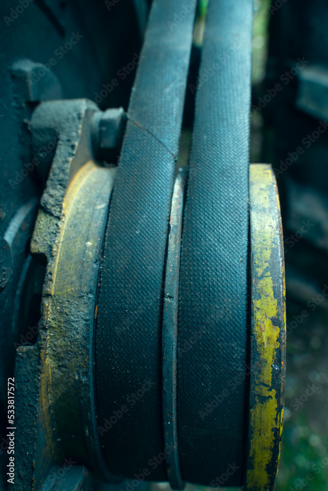 Two thick belts on the engine close-up. Drive belt old worn out on a ...
