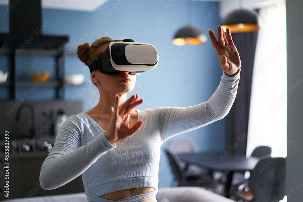 Woman in virtual reality goggles enters metaverse, controls immersive ...