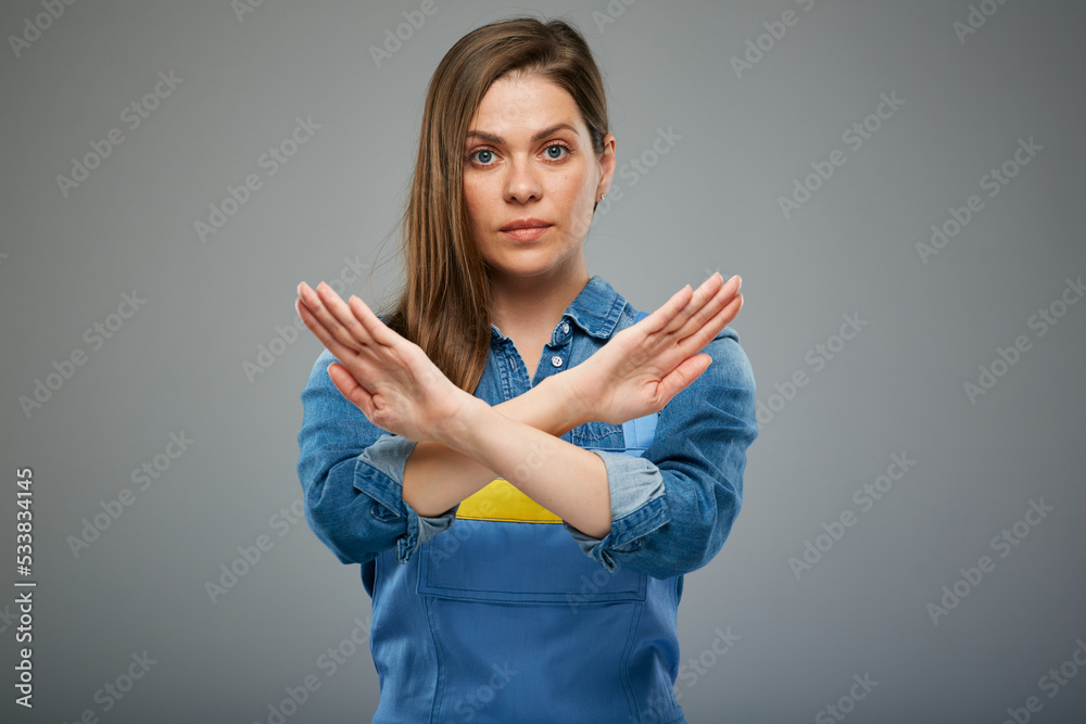 Woman in blue overalls showing stop sign. Isolated female portrait in ...