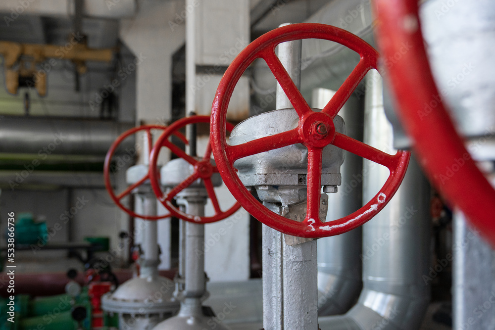 Valves on pipes in the boiler room. Valves of a large old boiler room ...