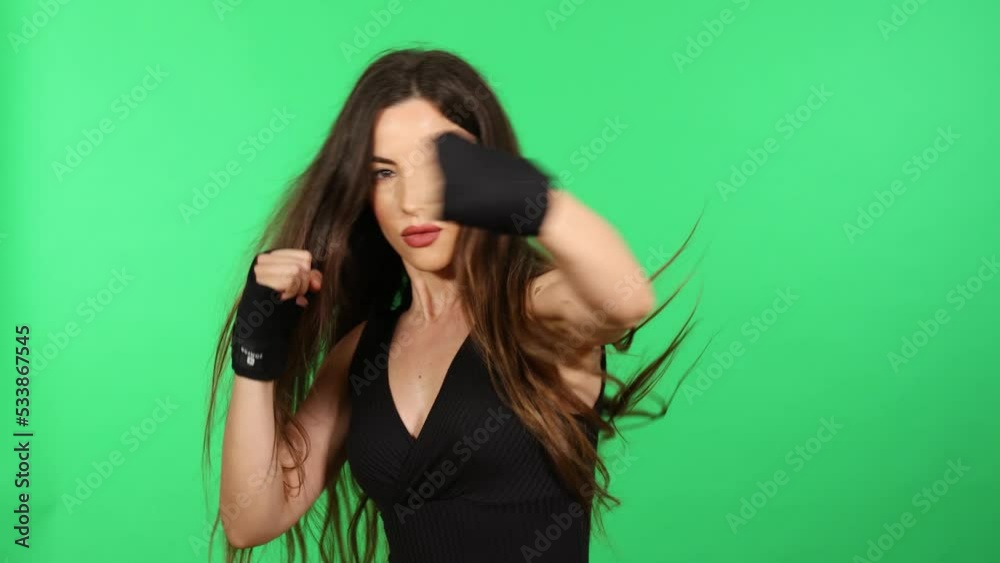 Beautiful female boxer punching looking at camera with boxing hand ...