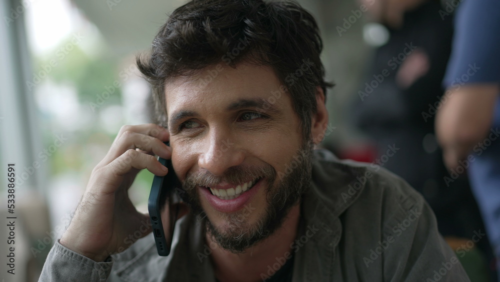 Man in 30s speaking with phone in ear. Person talking smiling holding ...