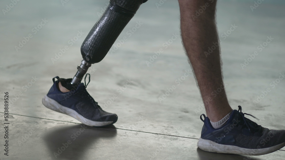 Disabled person walking with his prosthetic leg indoors. Amputee man ...