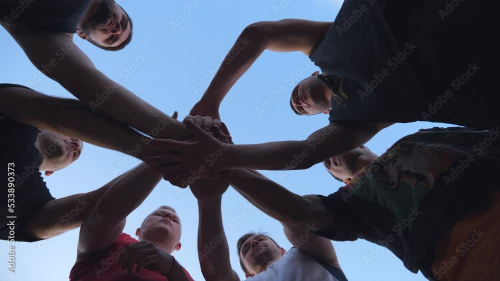 Young athletes stacking their hands together one by one in unity. Group ...