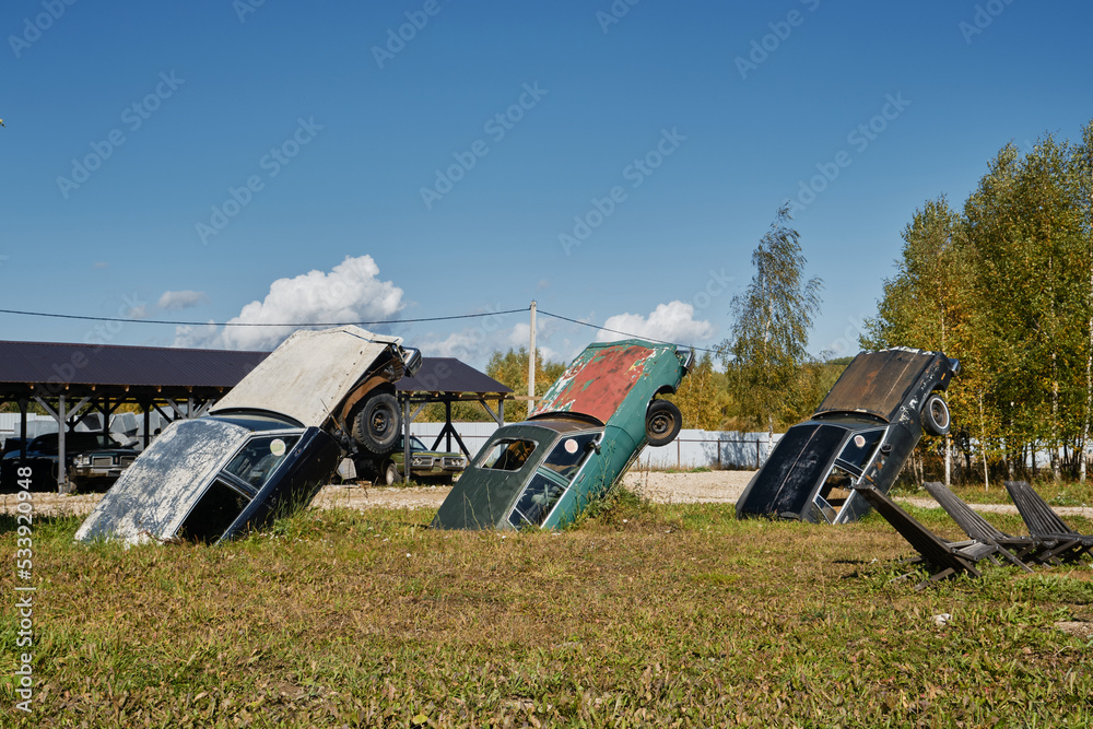 Russia, Moscow - September 2022. Rusty retro cars stick out of ground ...