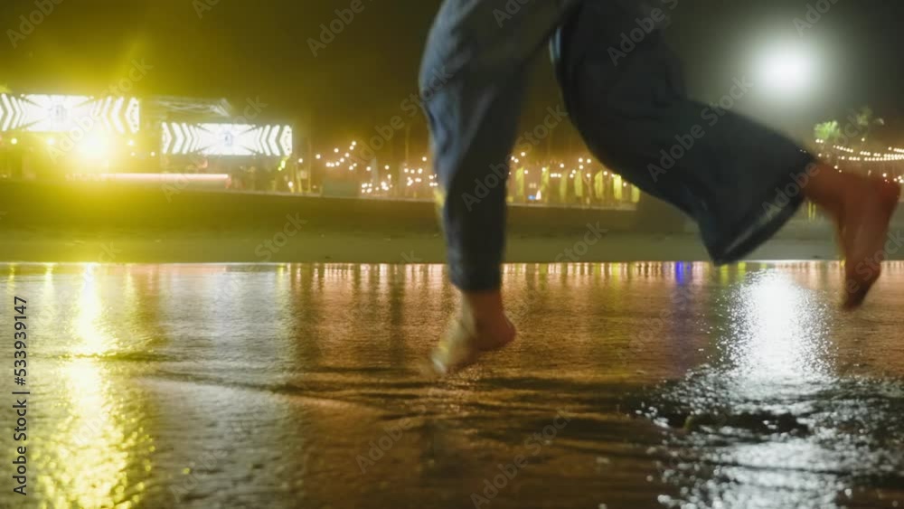 Female feet dancing hip-hop on wet sand with wave rolling on beach ...