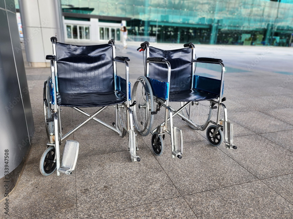 Two blue wheelchairs are lined up in front of hospitals or shopping ...