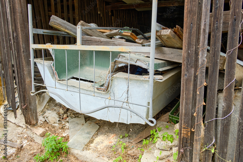 Neglected plastic boat full of junk in a derelict barn. Stock Photo ...