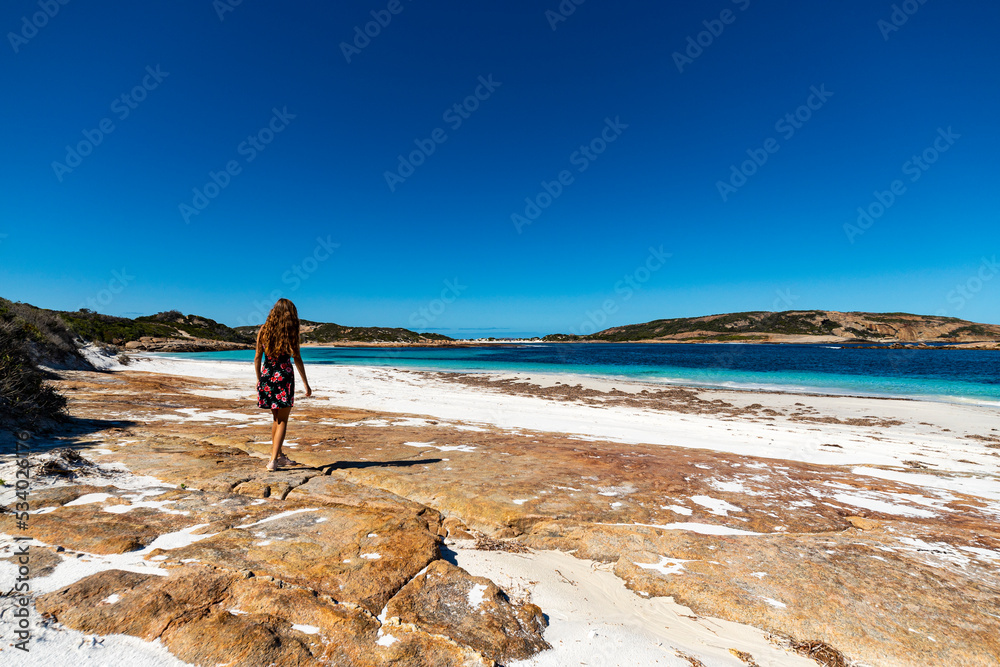 long-haired girl in a black dress with roses walks along a paradise ...