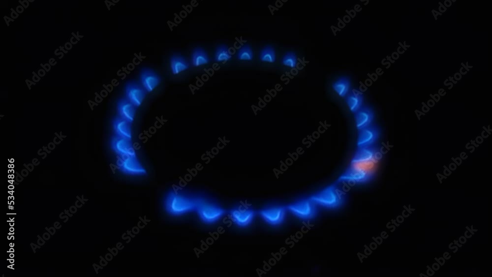 Gas stove kitchen burner flaming in the dark, close up. Methane firing ...