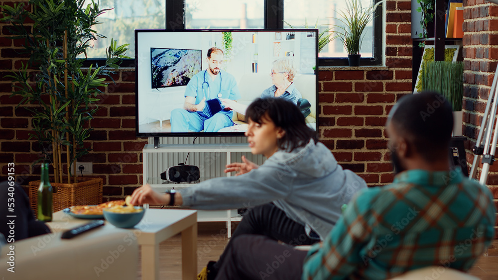 Diverse people drinking beer and watching movie on television, relaxing ...