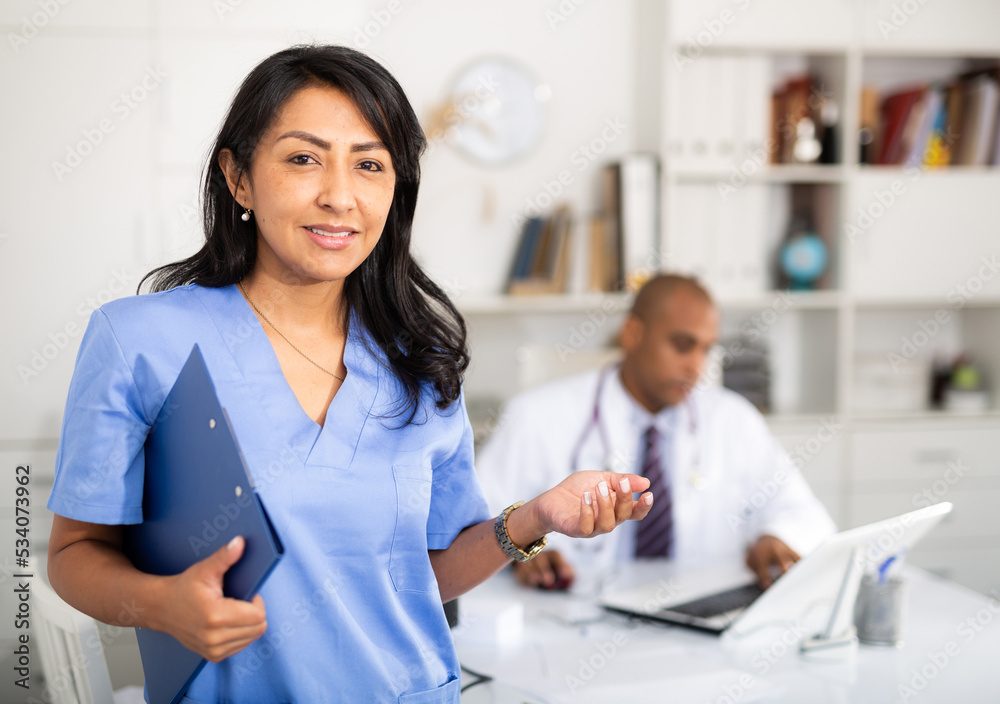 Polite female doctor making welcome gesture, politely inviting patient ...