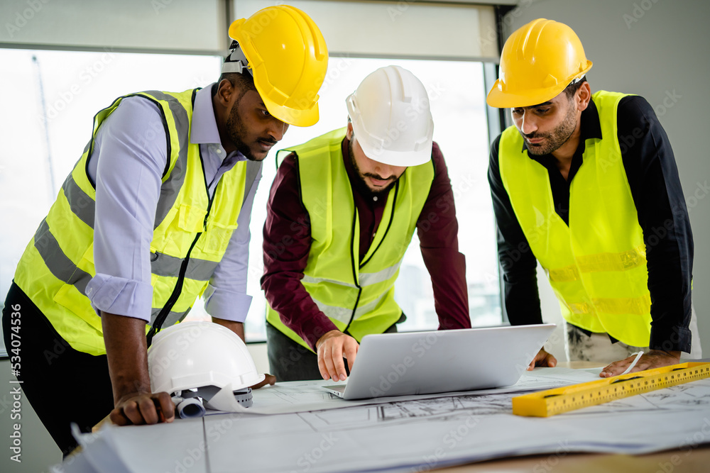 Team of Engineers diverse in safety suite discussing architectural ...