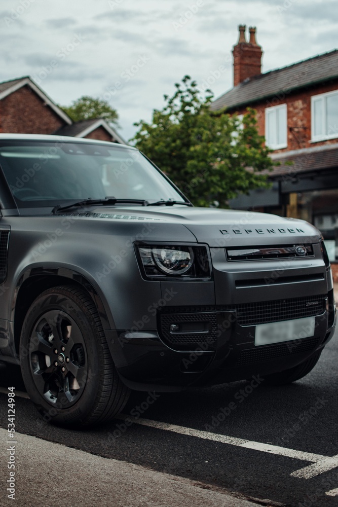 Vertical of a matte black Land Rover defender car in an upmarket and ...