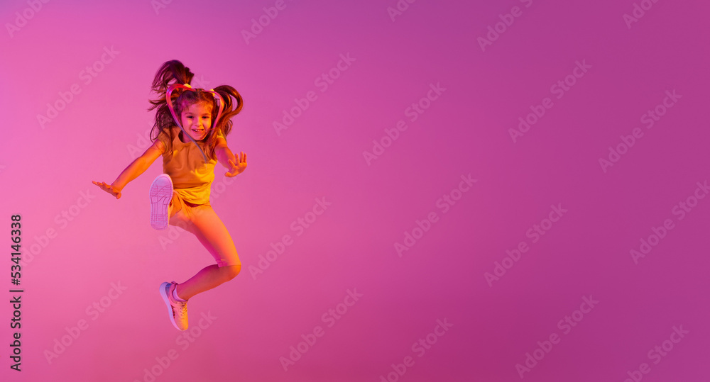 Beautiful active little girl, kid jumping, dancing isolated over pink ...