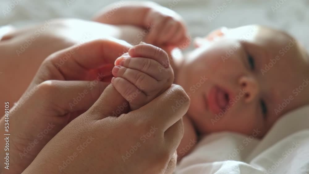 Baby hand in mother hands, on her palm. Happy parents holding their ...