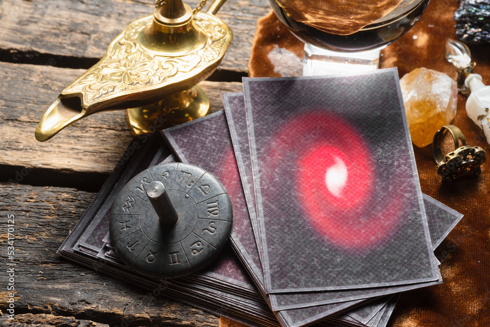 Tarot cards and zodiac wheel amulet on the old fortune teller desk ...