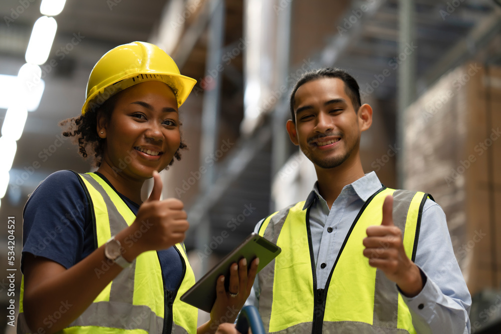 Black woman with yellow helmet and man warehouse worker show thumb up ...