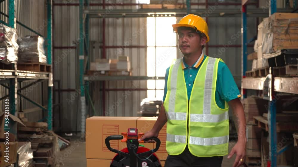 Asian warehouse worker wearing a safety helmet and reflective vest ...