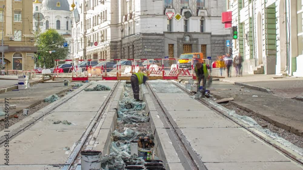 Workers do cleaning of the railway tram line after construction works ...