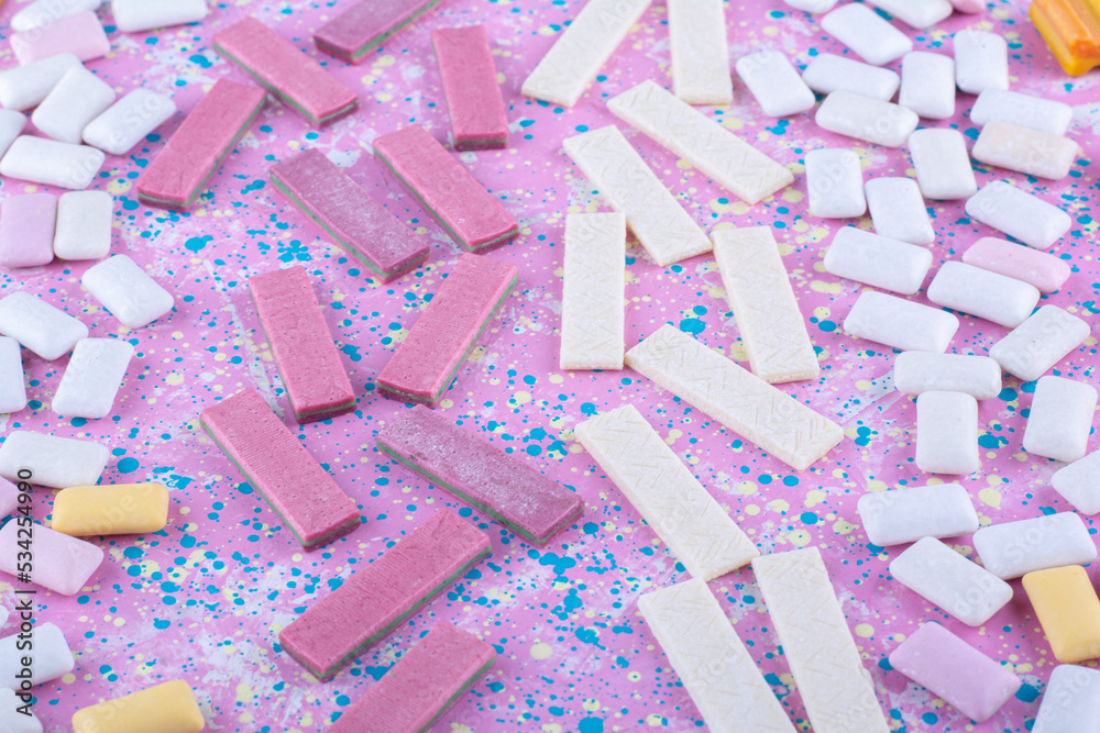 Variety of chewing gum tablets scattered over a colorful background ...