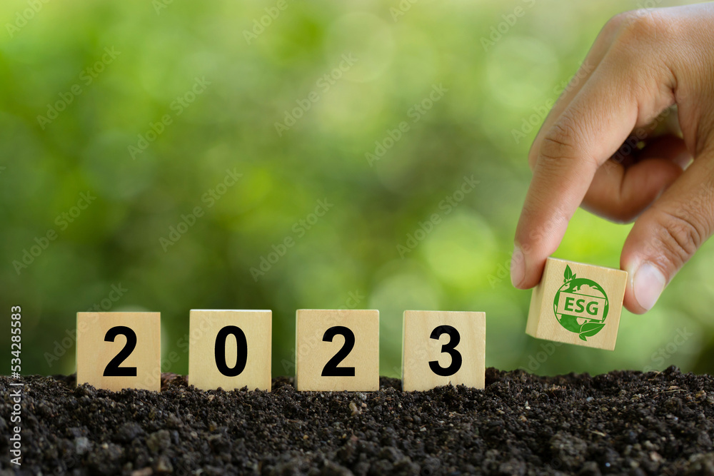 Happy New Year 2023 on the wood cube block on green background ...