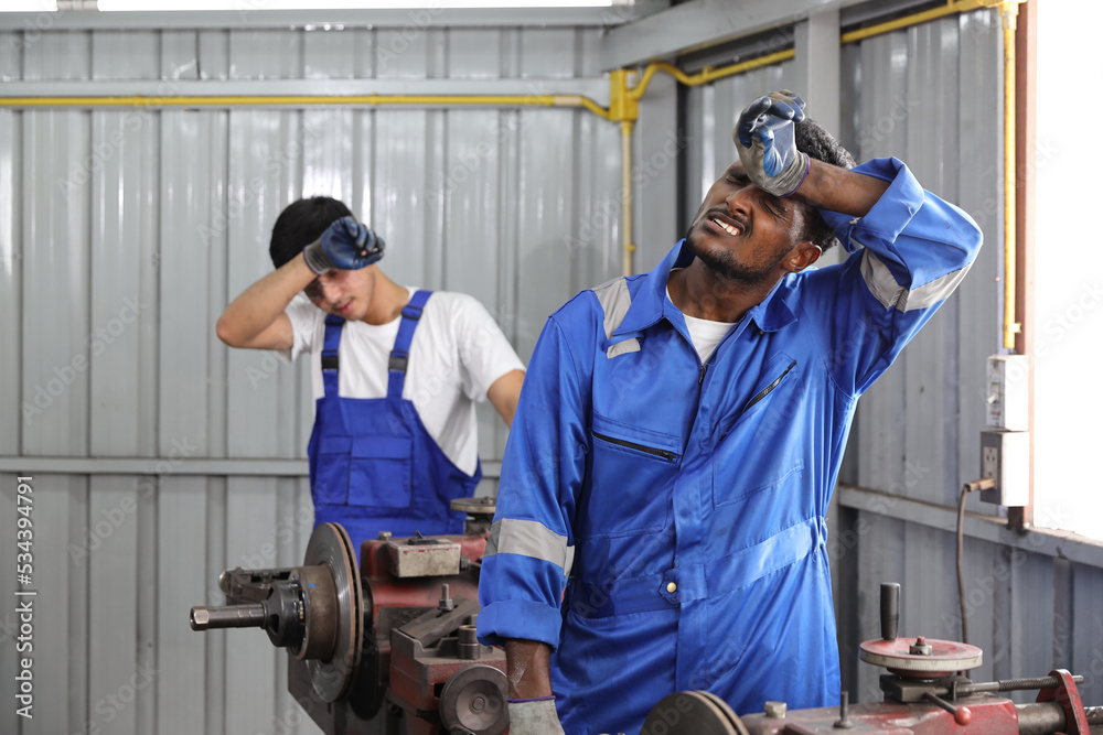 Fotka „Tired heat and hot technician mechanic men in uniform using ...