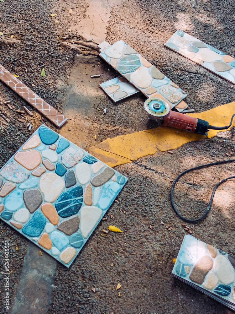 Old red angle grinder with rotary blade on aluminum surface with tiles ...