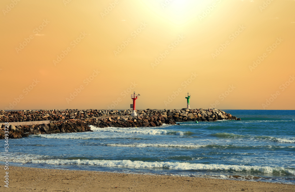 Lighthouse on Wave breaker and Stone pier at sea. View of the ...