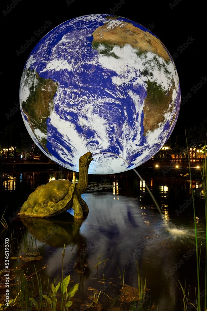 Sculpture fountain of a giant turtle with a large hologram of the ...
