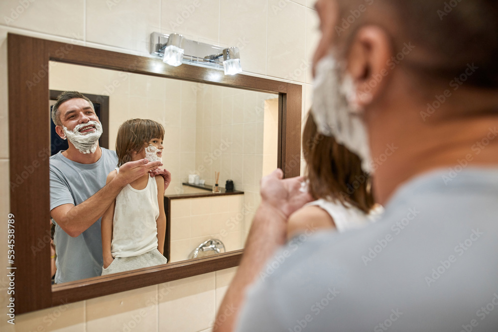 Mirror reflection of dad smear foam on son face Stock Photo | Adobe Stock