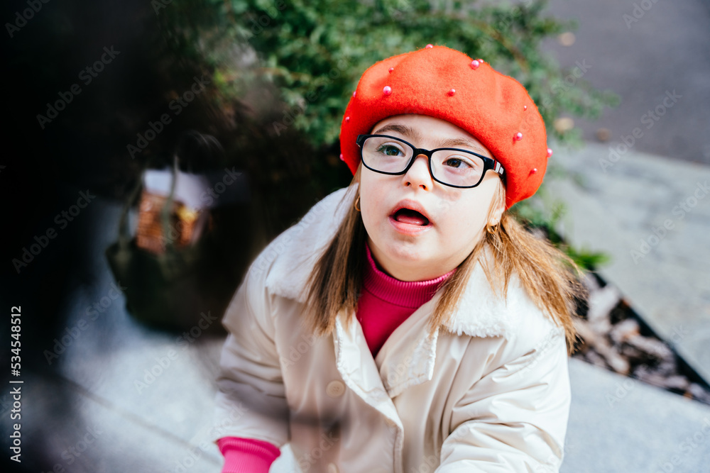 Cute inquisitive little girl in eyeglasses with special needs looking ...