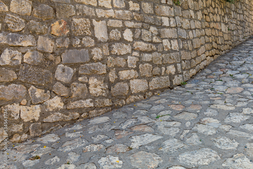 Stone wall and stone road or sidewalk in the architecture of the old ...