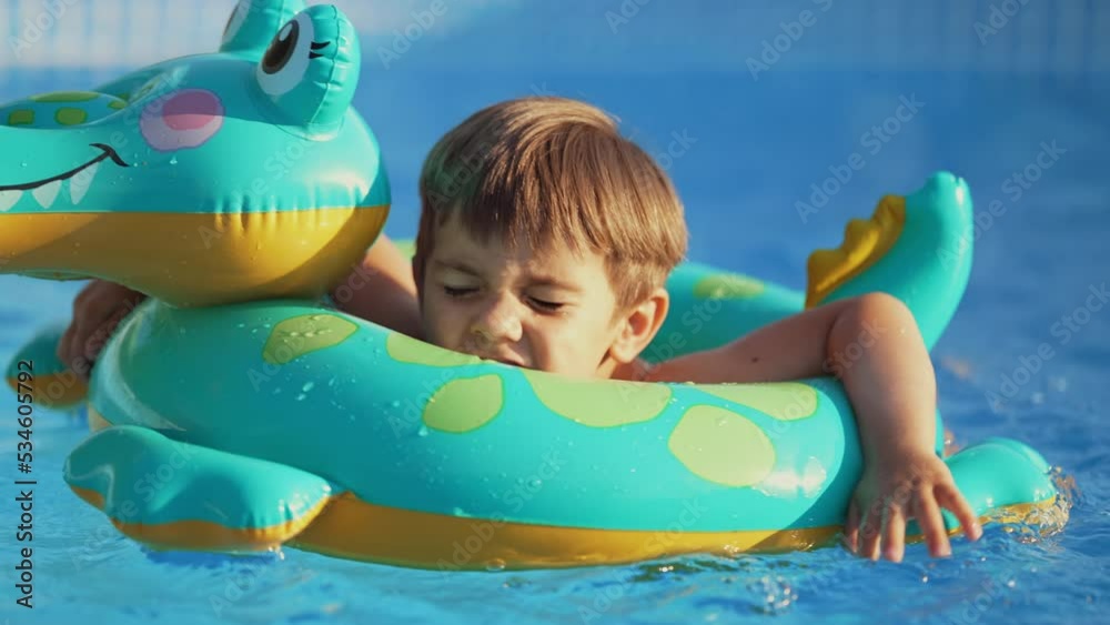 Little boy in blue street pool in courtyard. Joyful toddler, baby in ...
